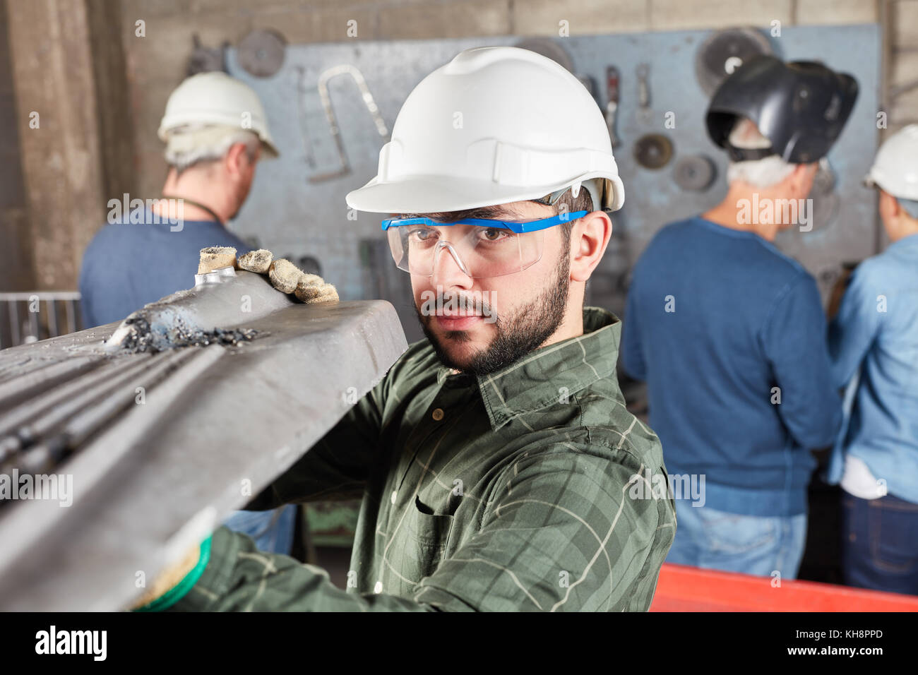 Quality control in metallurgy factory with worker carrying metal ...