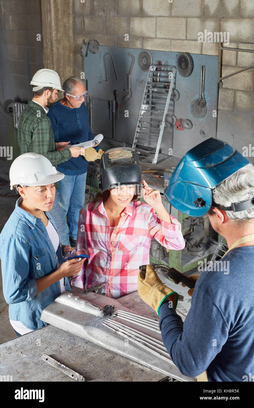 Women in welding lessong during apprenticeship in metallurgy workshop ...