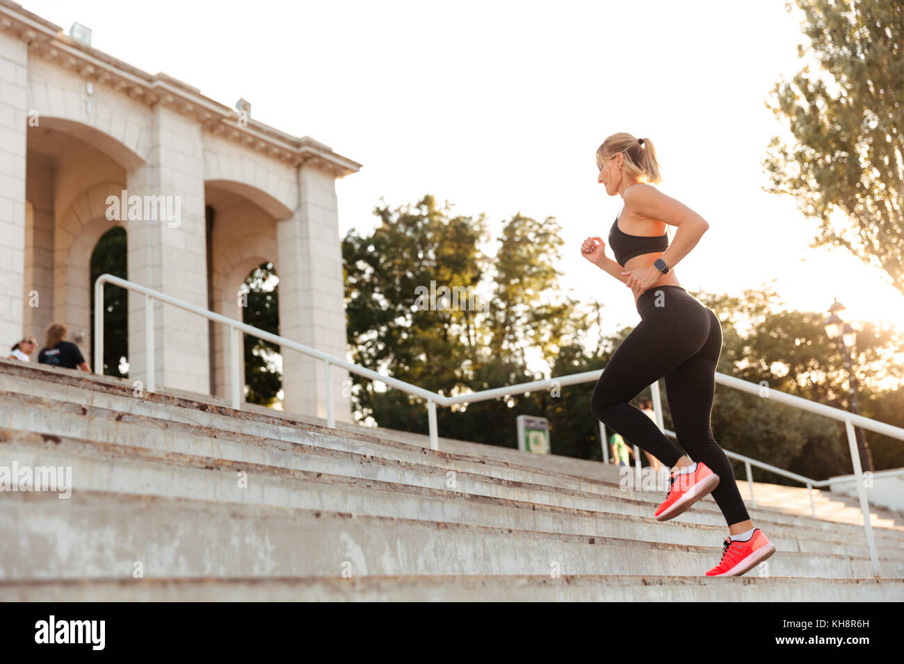 Image of gorgeous strong young sports woman running on steps outdoors ...