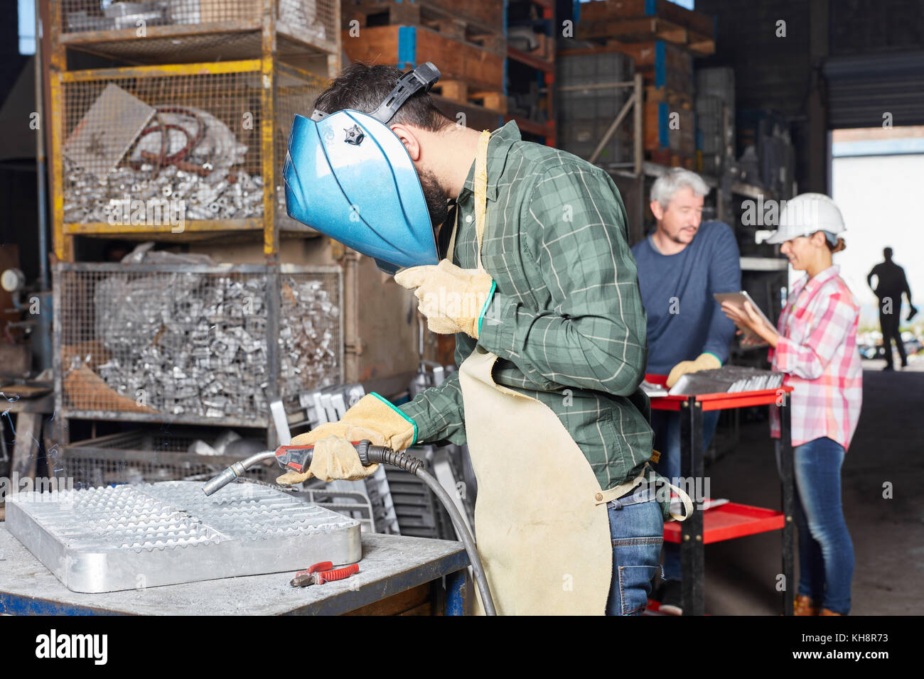 Metal factory workers and welders working together in workshop Stock ...