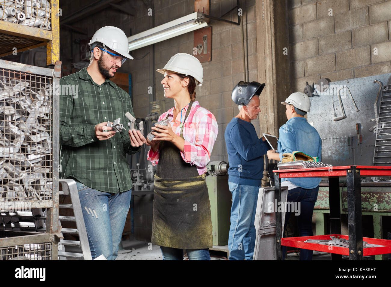Metalworking workshop with two young apprentice in metallurgy factory ...