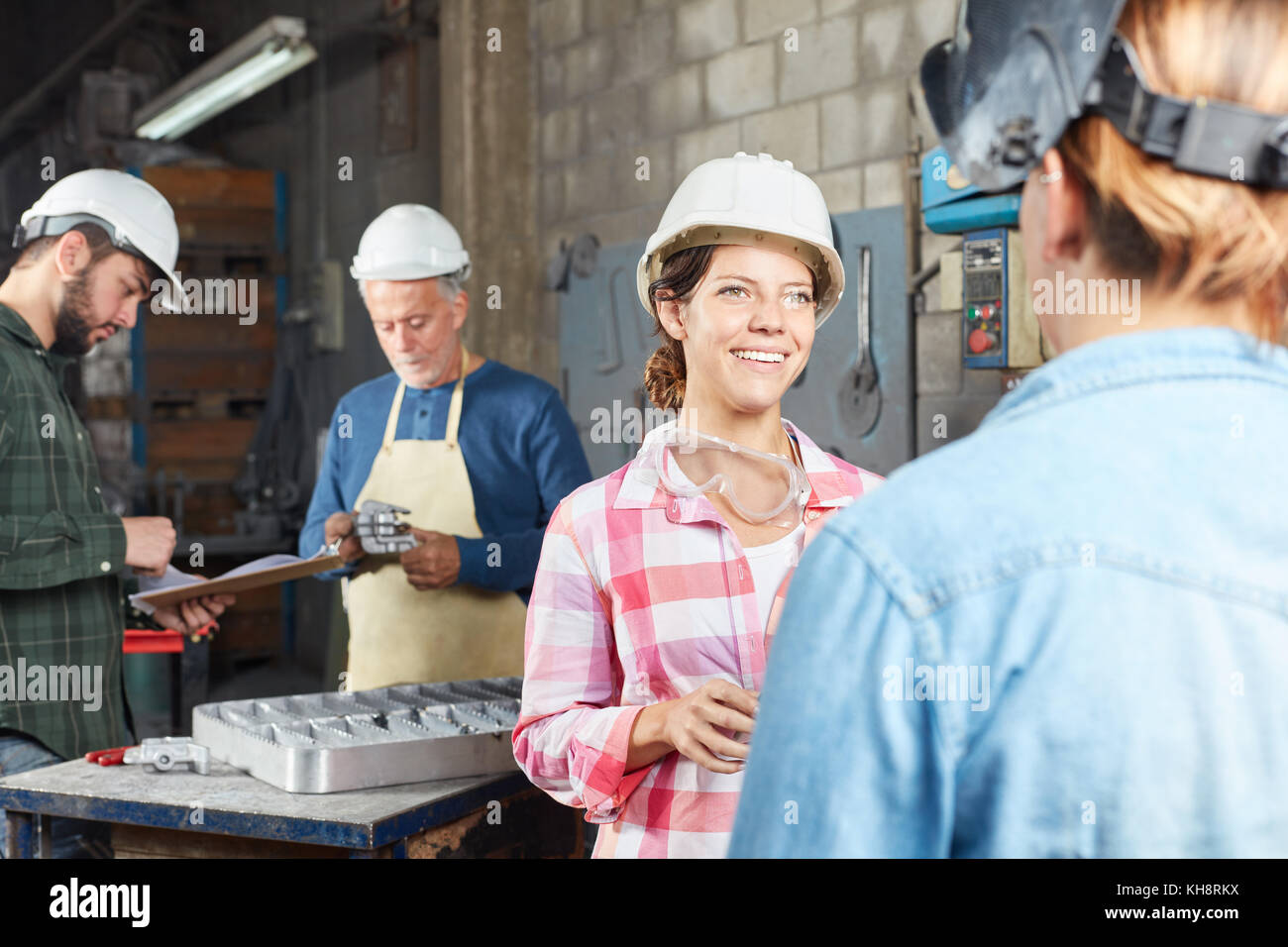 Young woman as worker apprentice with colleaguen Stock Photo - Alamy