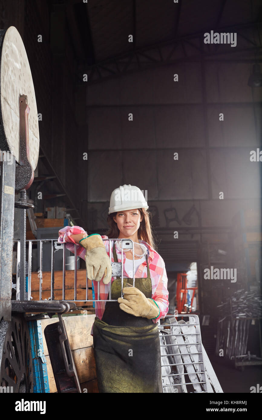 Young woman in metal construction apprenticeship in metallurgy workshop ...