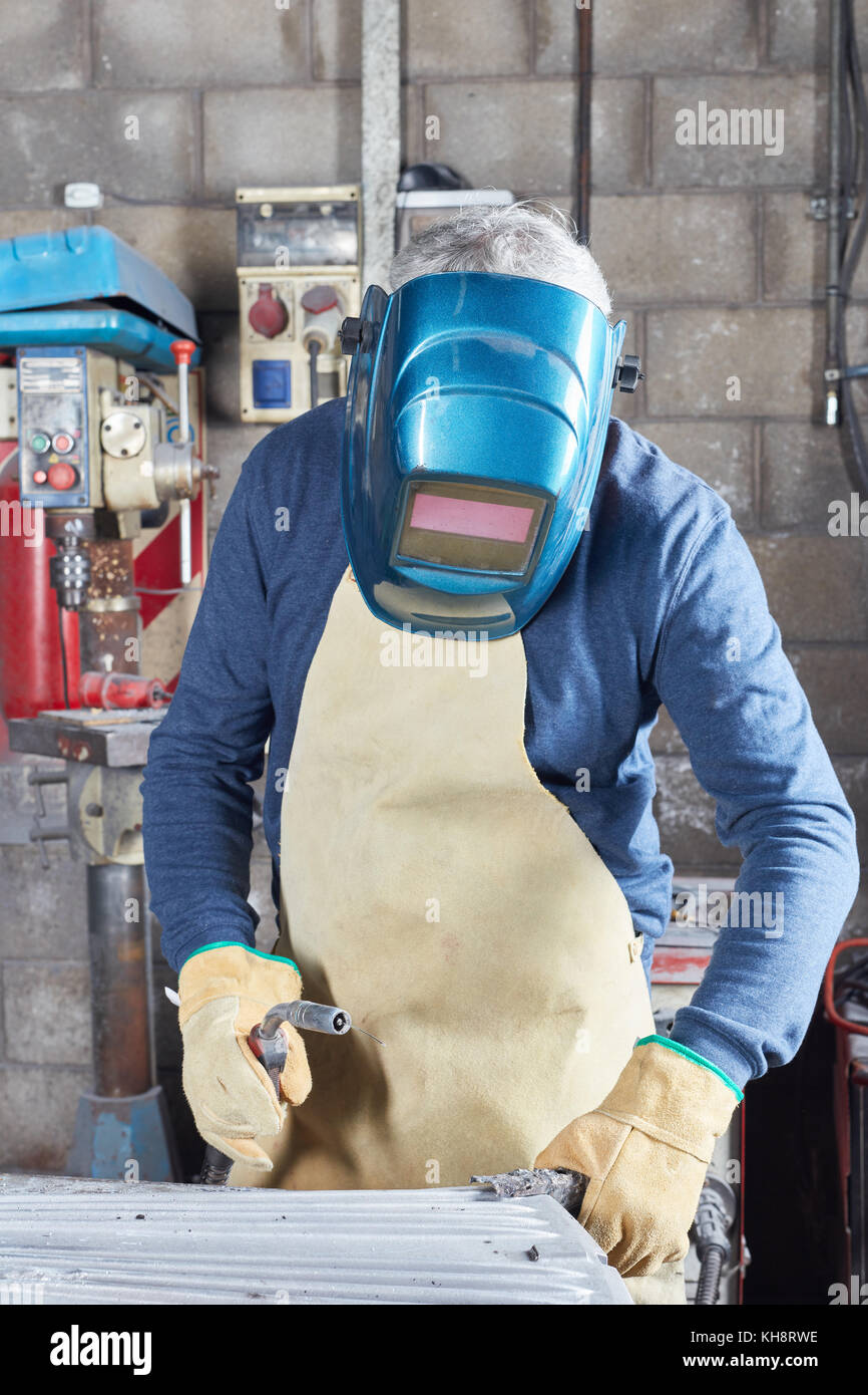 Welder using protective clothing and helmet as labor protection concept ...