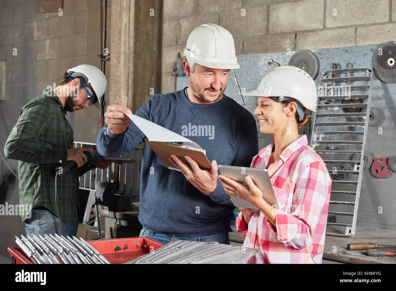 Young woman as apprenticeship trainee with blue collar worker ...