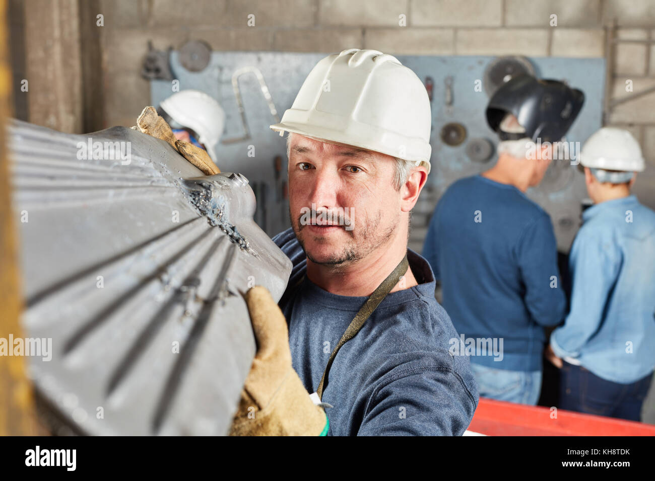 Worker in metallurgy factor carry metal component Stock Photo - Alamy