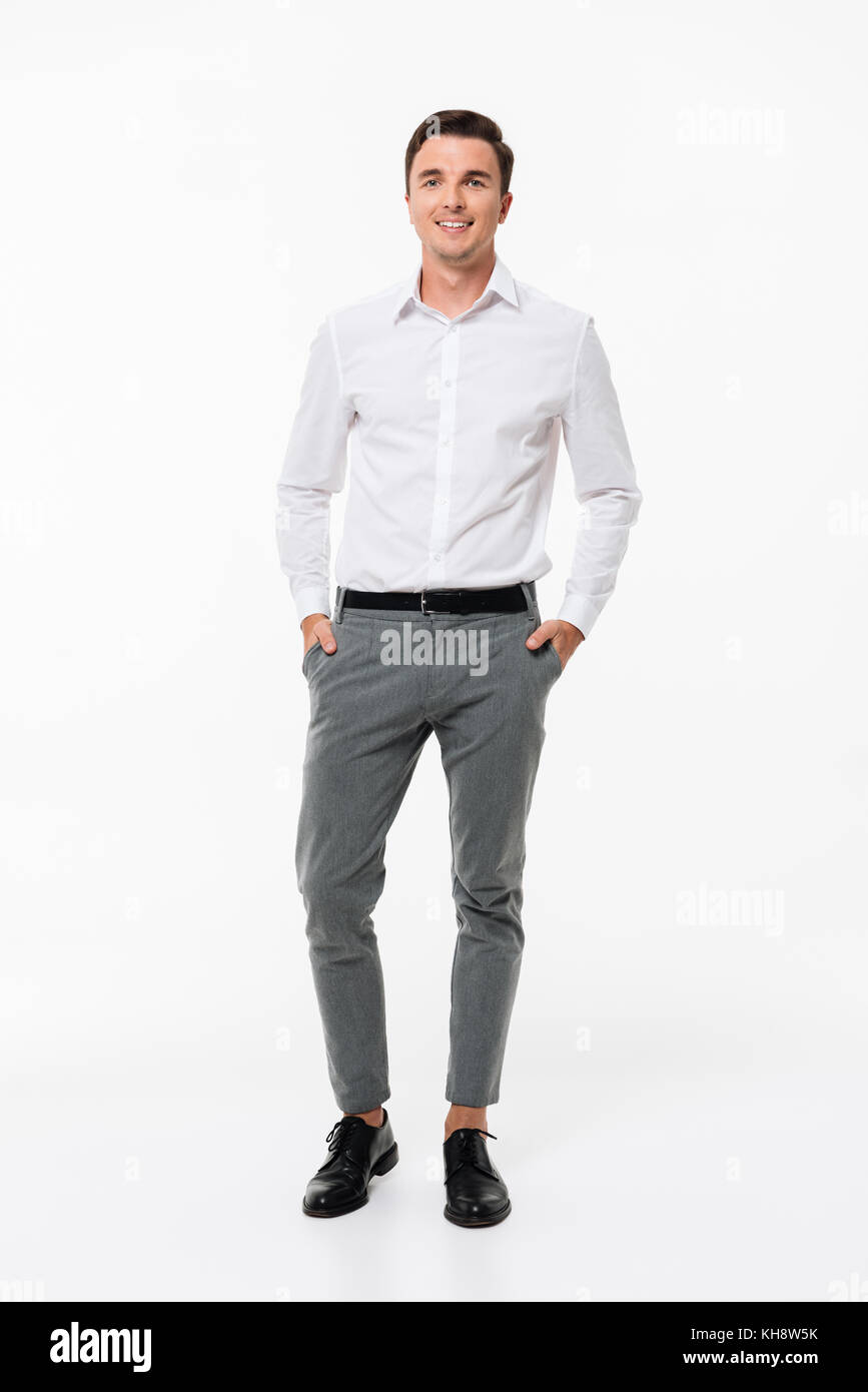 Full length portrait of a cheerful young man in a white shirt standing ...