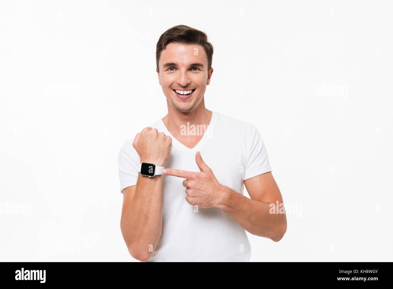 Portrait of a cheerful smiling man pointing finger at smart watch ...