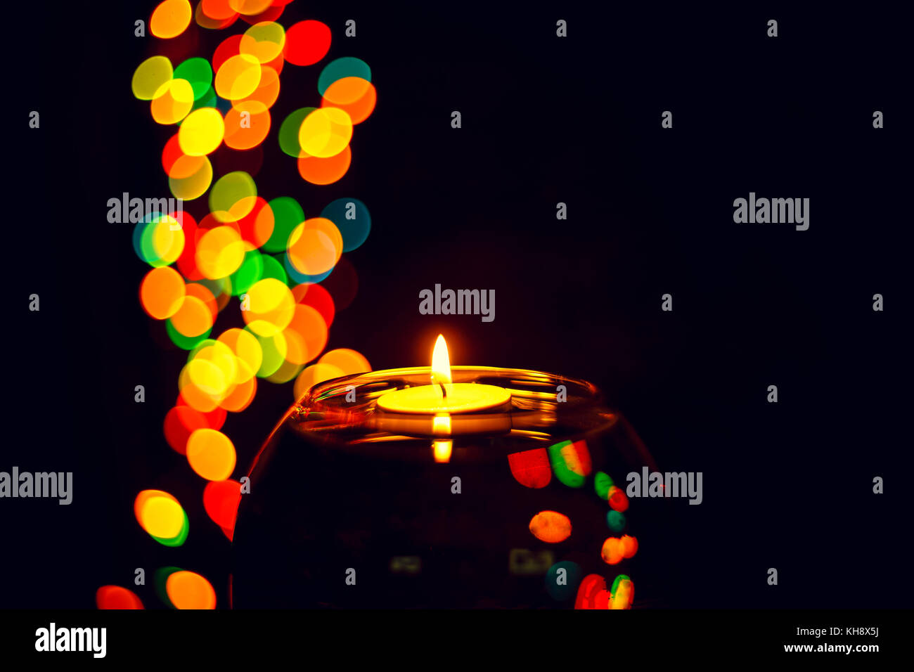Floating candle and multi-colored garland. Christmas background. Copy ...