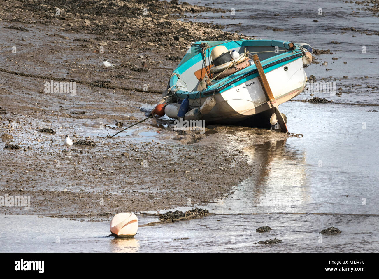Keeled over tender boat in Morston Creek Stock Photo - Alamy