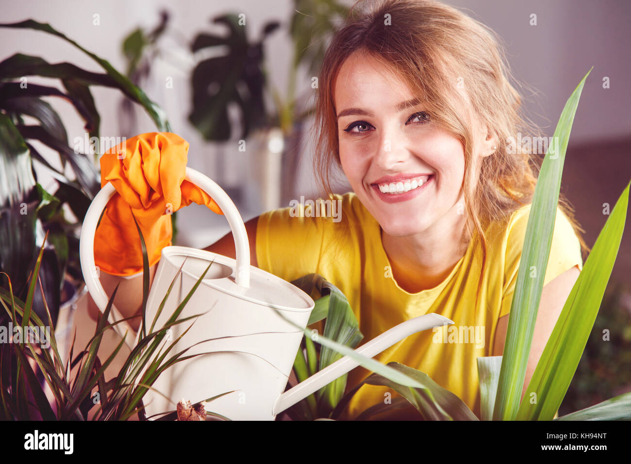 Cheerful girl taking care of green plants Stock Photo - Alamy