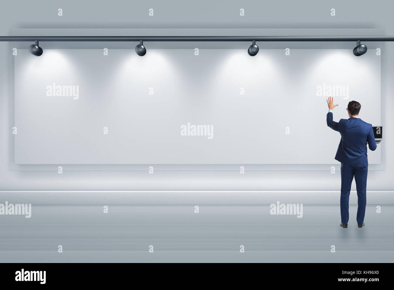 Businessman pressing virtual button on the wall lit with spotlights ...