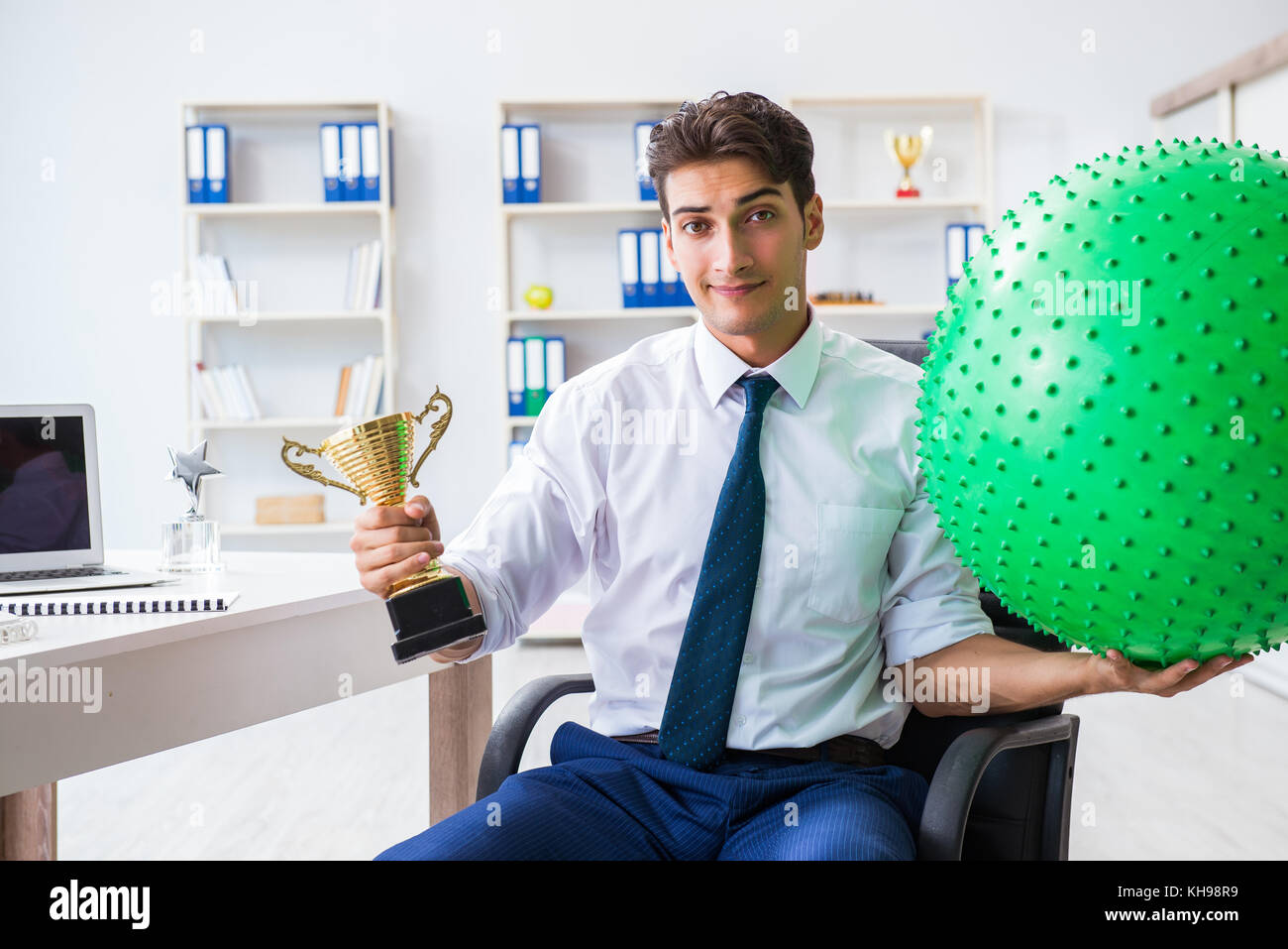 Young businessman doing sports stretching at workplace Stock Photo - Alamy