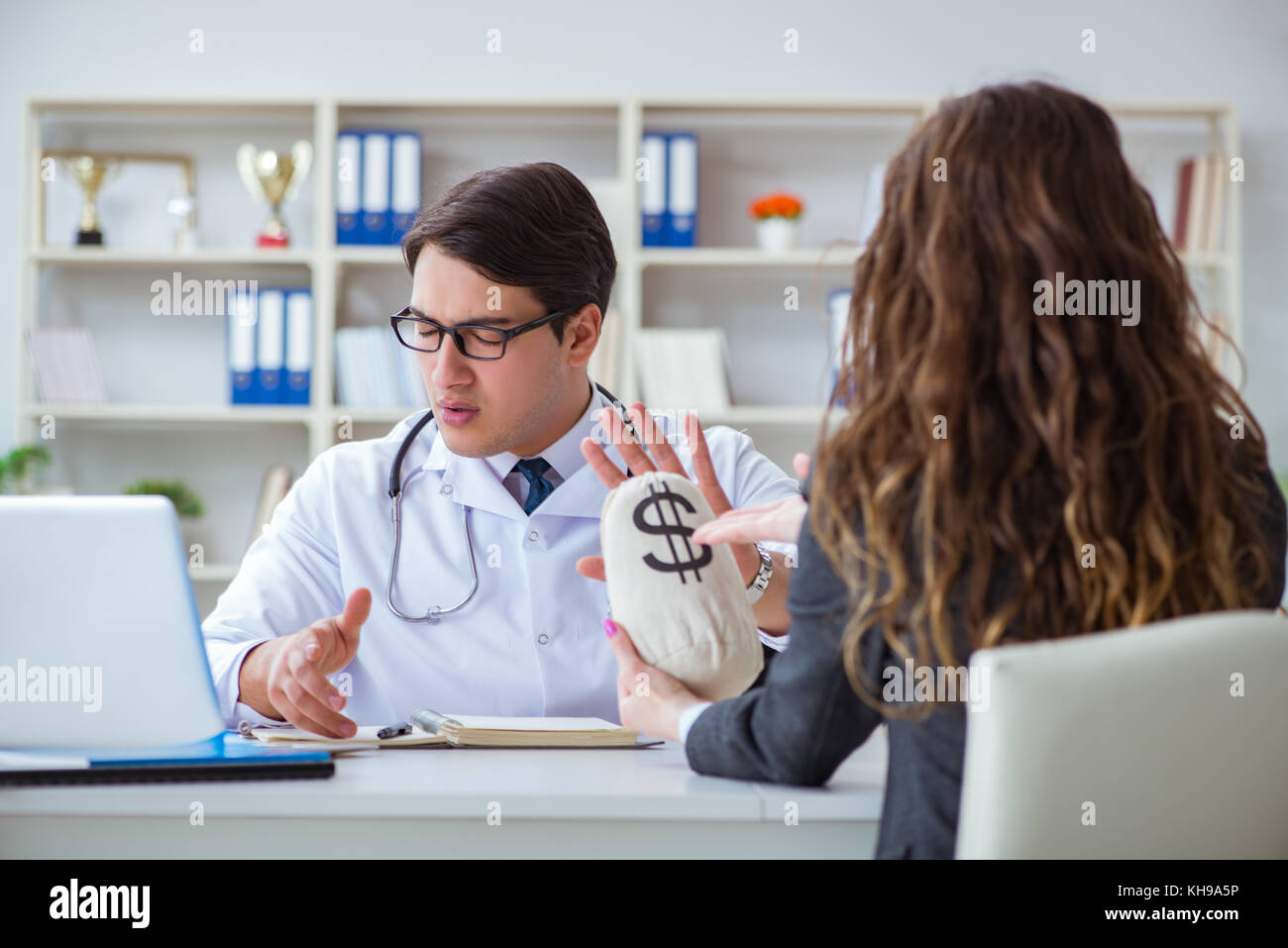 Young doctor in medical insurance fraud concept Stock Photo - Alamy