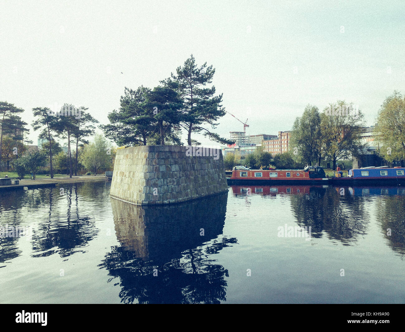 canal water with canal boat and island with tree in the middle of it ...