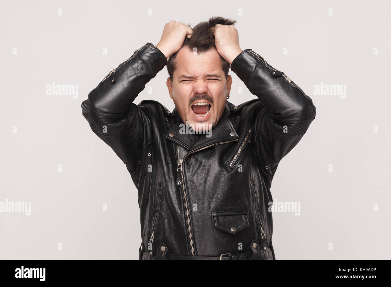 Anger man scream at camera and holding head. Studio shot Stock Photo ...