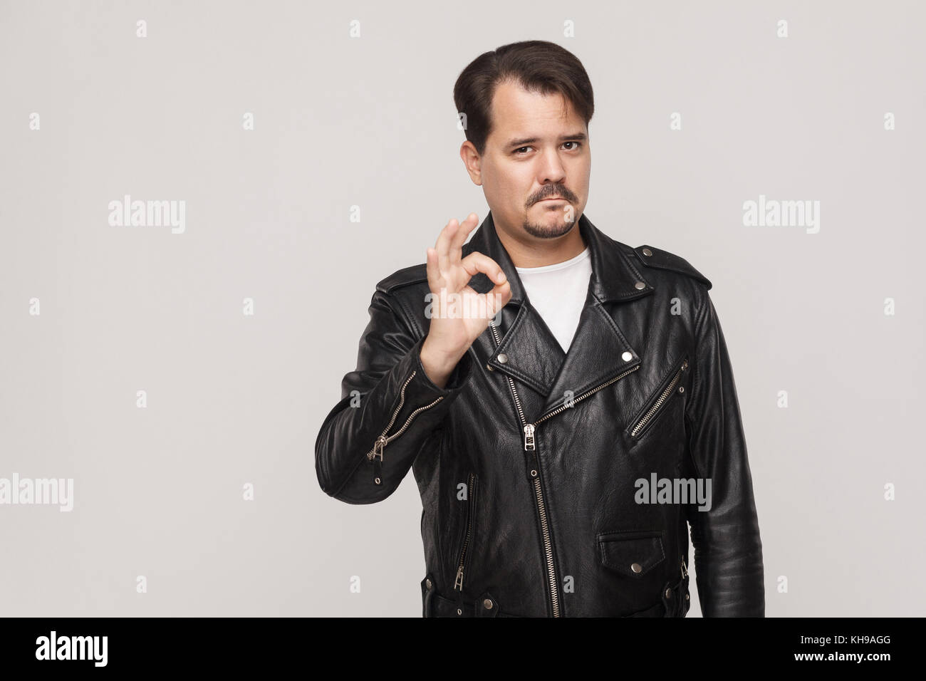 Rocker man showing okay sign and looking at camera. Studio shot Stock ...