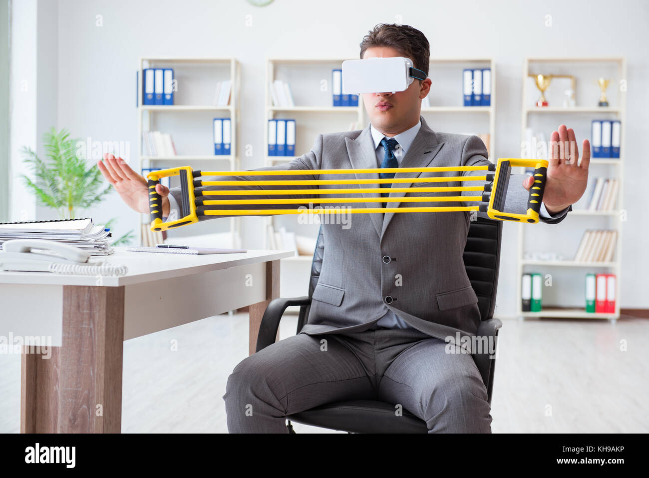 Businessman exercising with elastic expander wearing VR glasses Stock ...