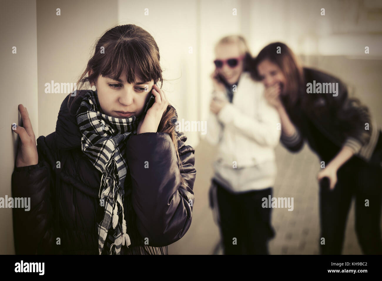 Sad teen girl calling on cell phone at the wall Stock Photo - Alamy