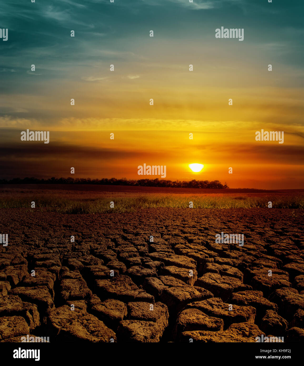 dramatic sunset over cracked earth Stock Photo - Alamy