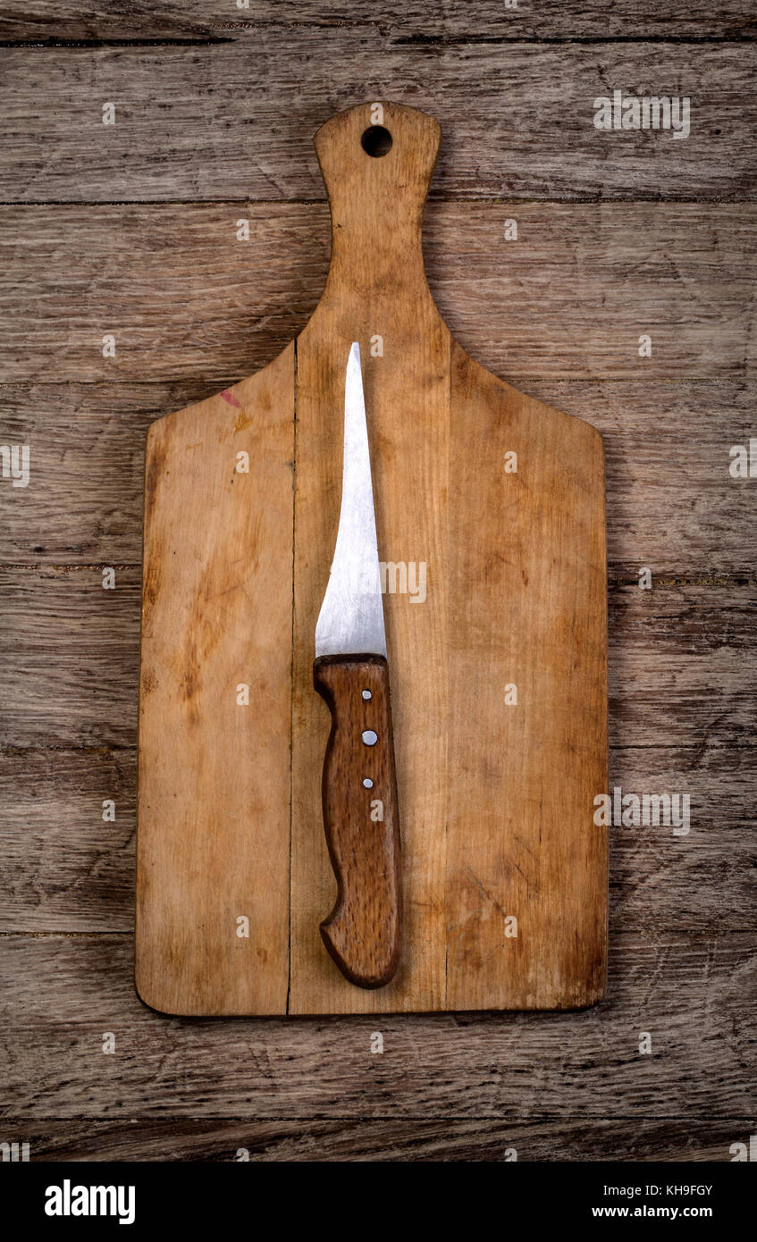 Empty chopping board with a knife on a distressed grunge wooden table ...