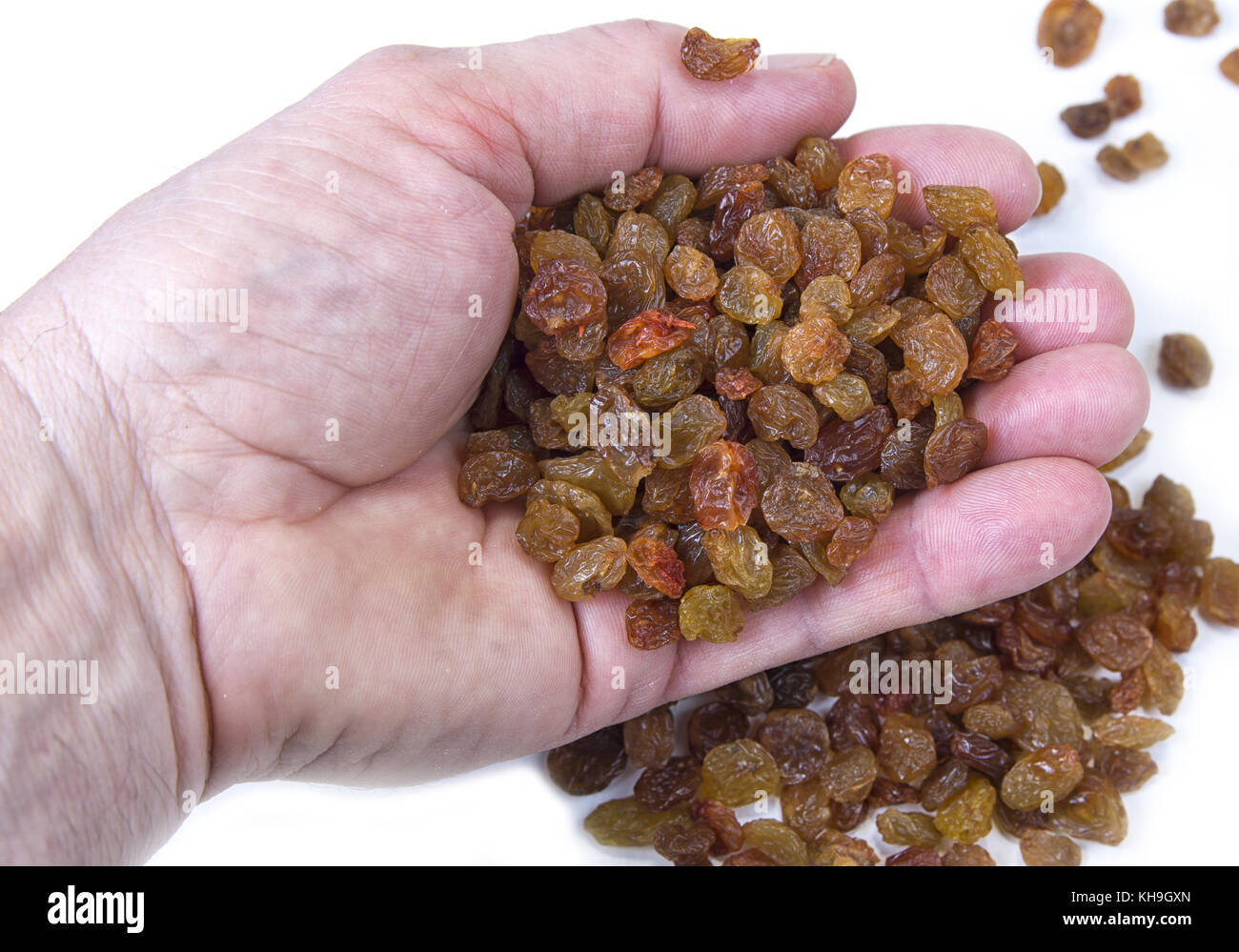 Sweet raisins in the hand on white background Stock Photo - Alamy
