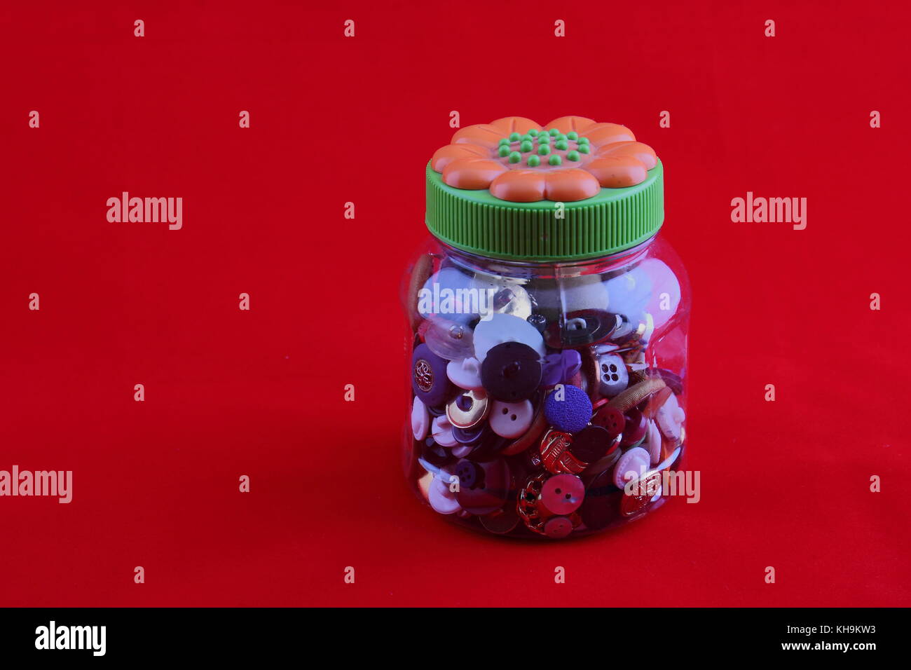 Glass container filled with a variety of colorful buttons in landscape ...