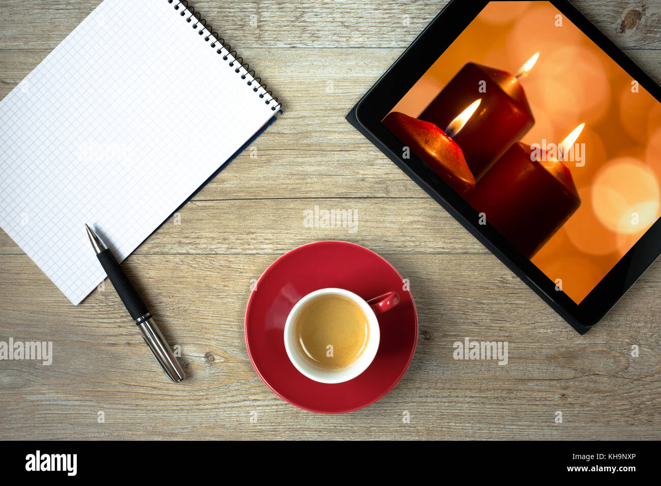 Tablet with picture of burning candles as top view with note pad and ...