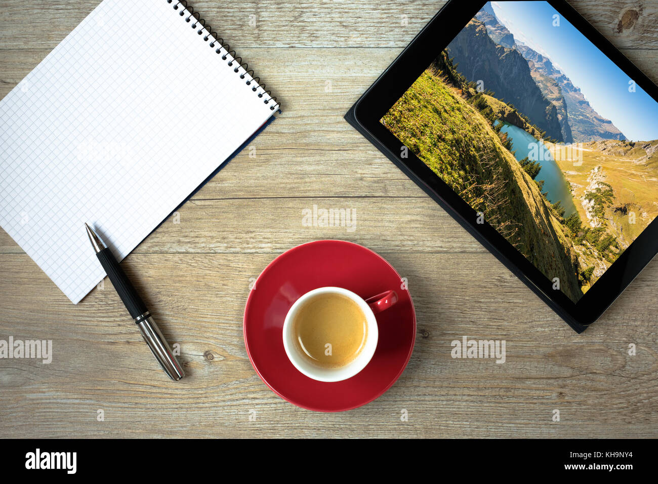 Tablet computer with picture of lake in the alps, note pad, ballpoint ...