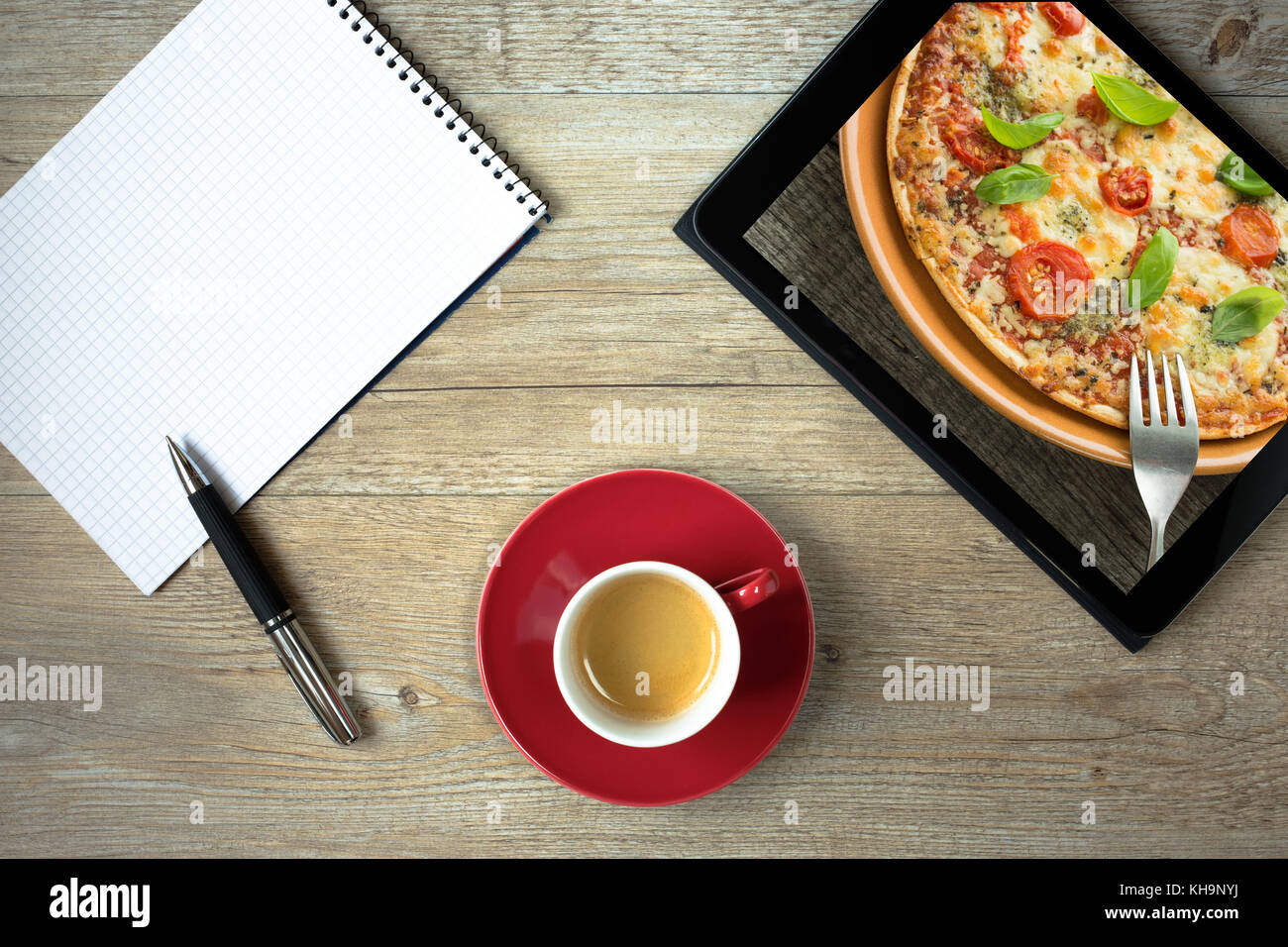 Tablet computer with picture of a pizza with tomatoes and basil on a ...