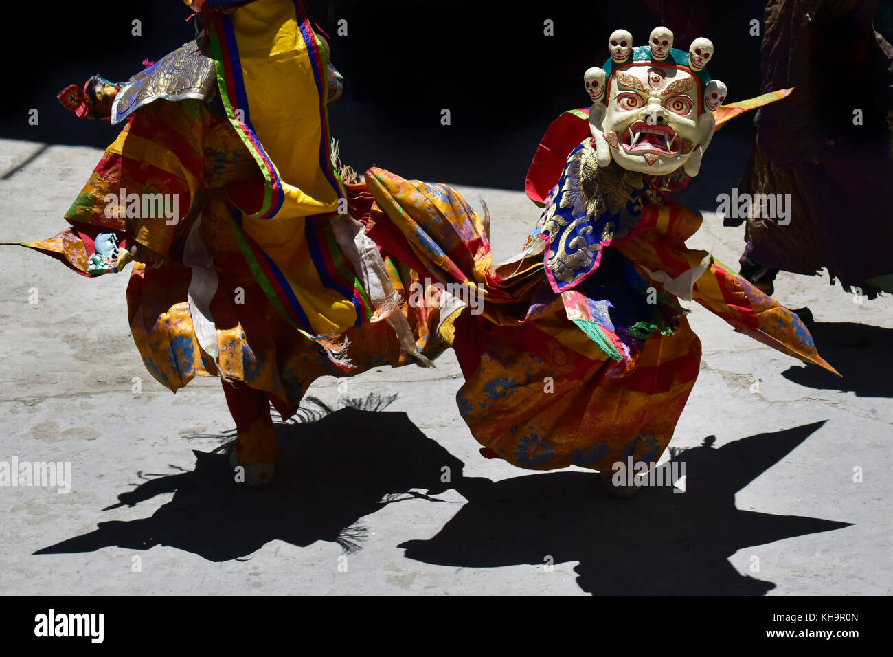 Two Buddhist lamas in ritual bright outfits and sacral masks with ...
