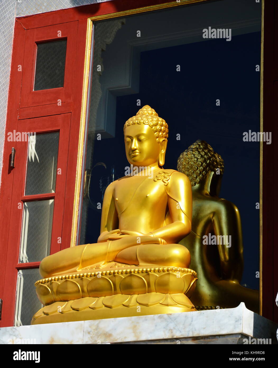 golden Buddha on the window Stock Photo - Alamy