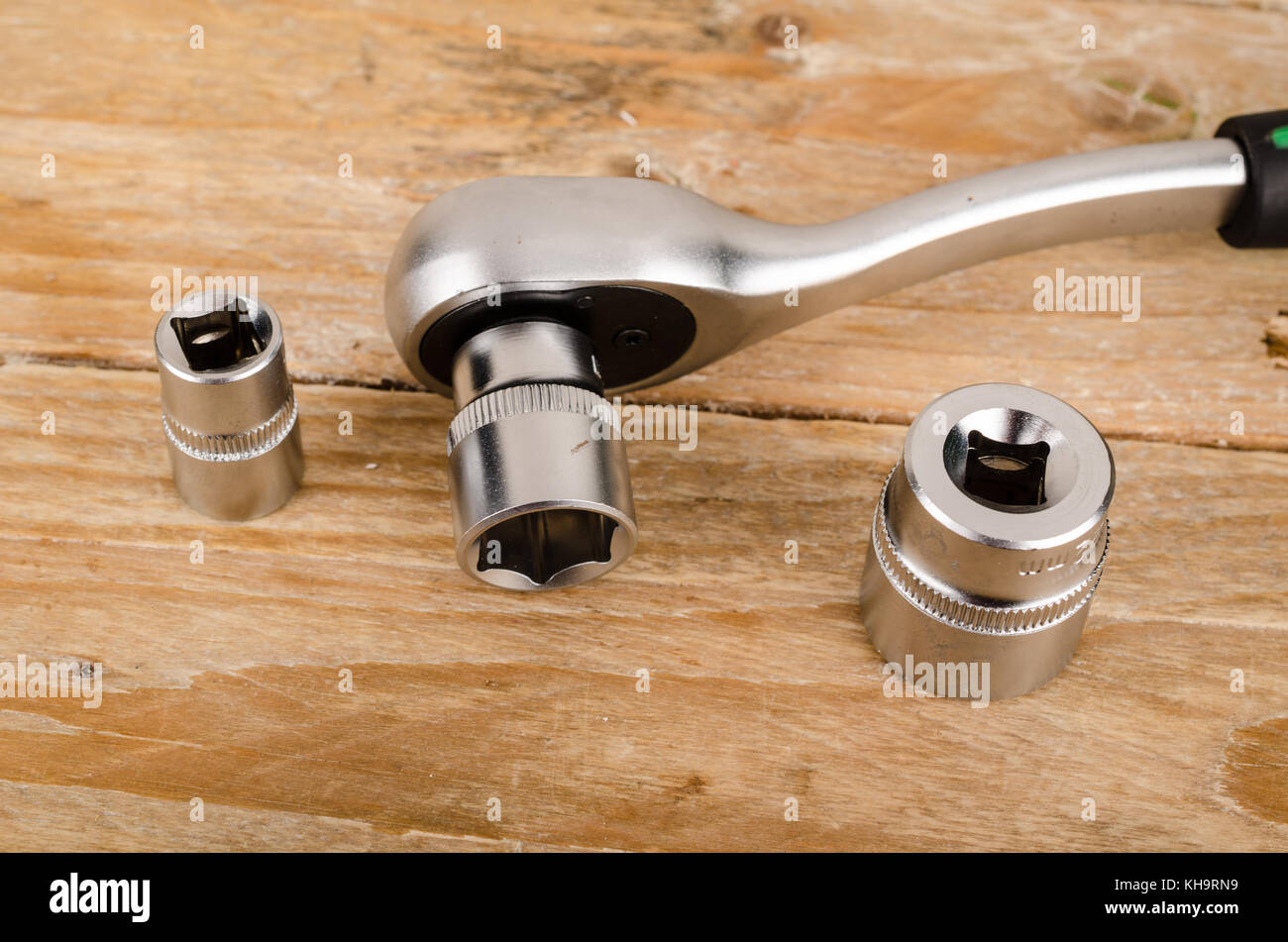 Ratchet wrench and different sized sockets on a wooden work bench Stock ...
