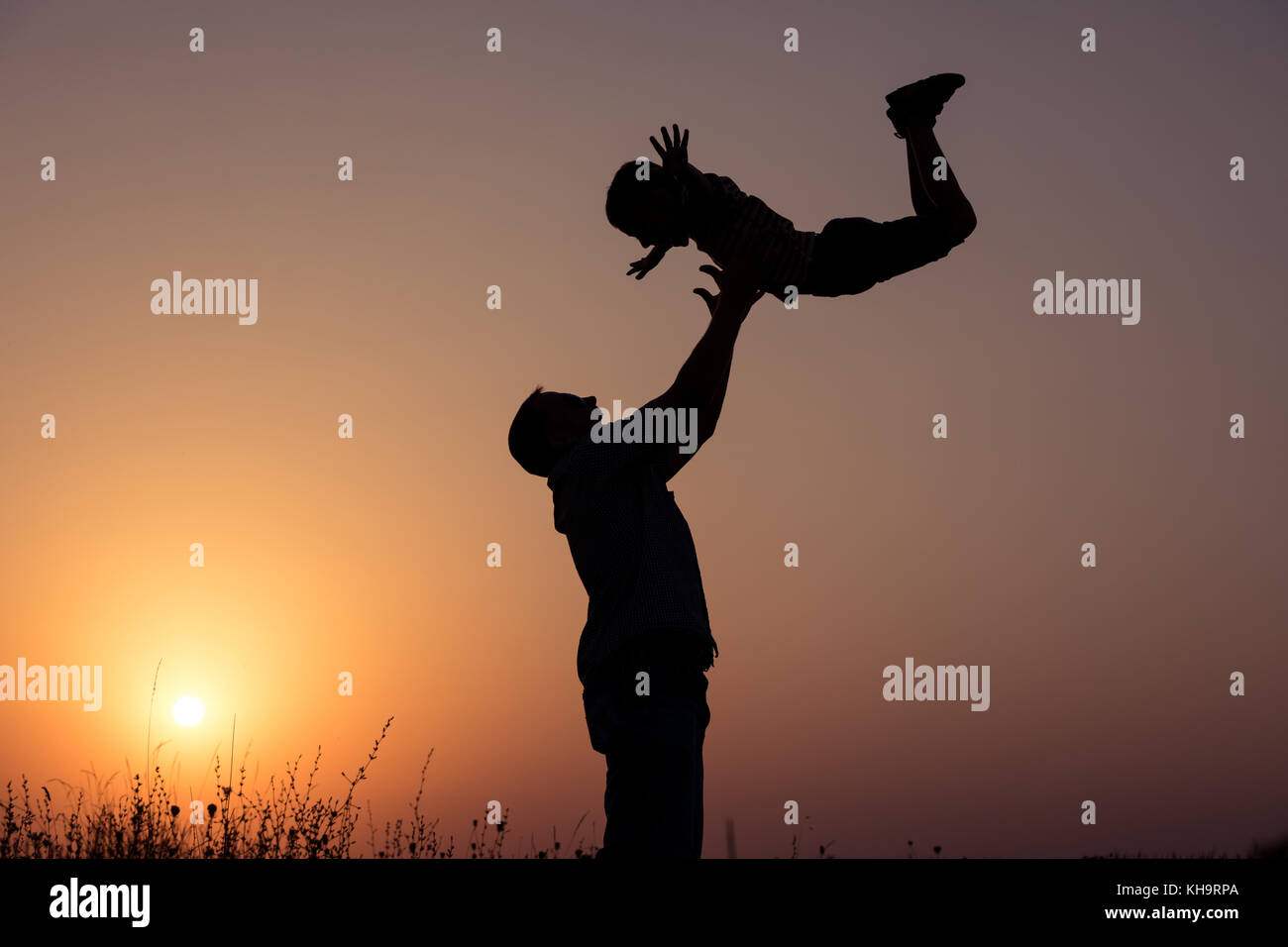Father and son playing in the park at the sunset time. People having ...