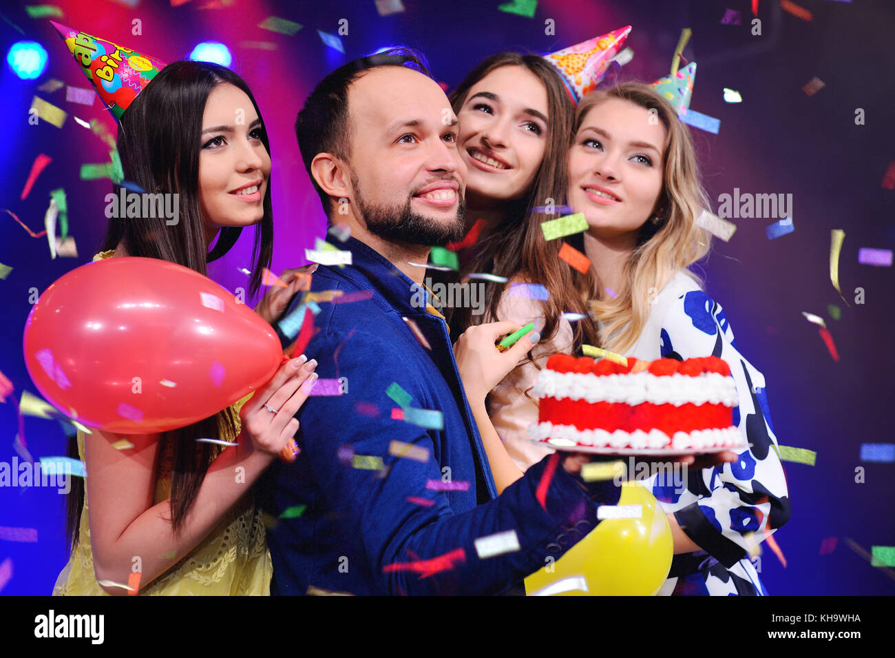 a guy and three girls rejoice and celebrate the party in the night club ...