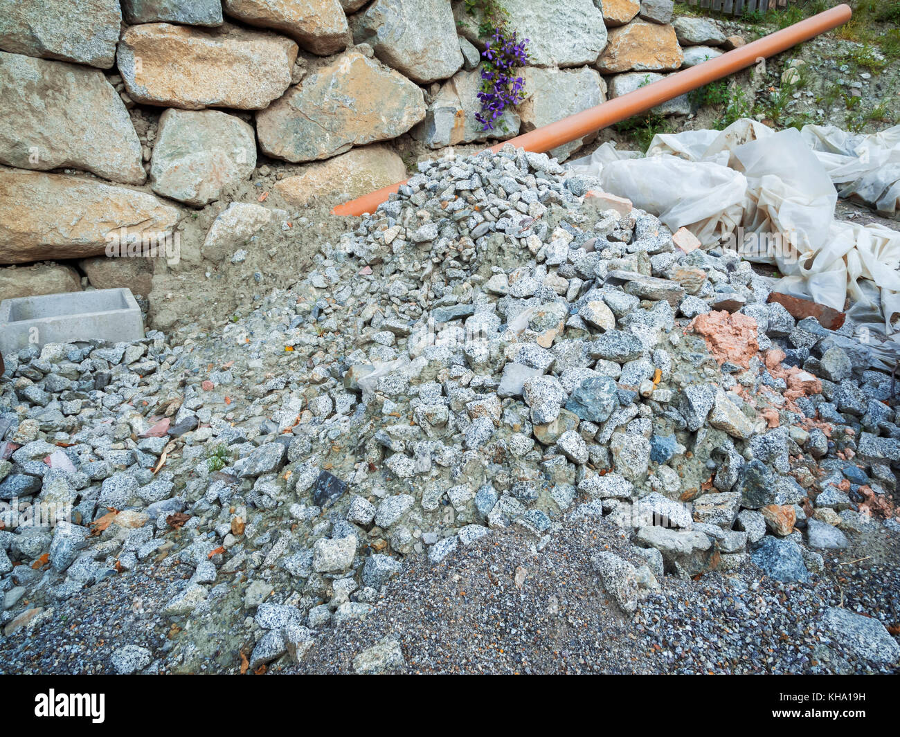 Detail of a small construction site with rock wall, gravel and a ...