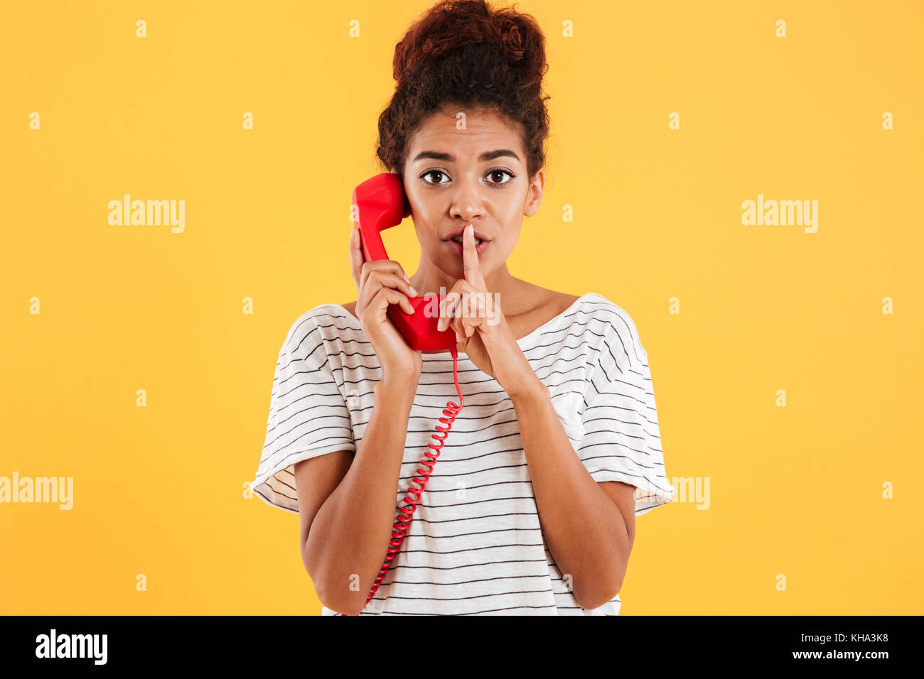 Nervous calm beautiful lady showing silence gesture while holding red ...