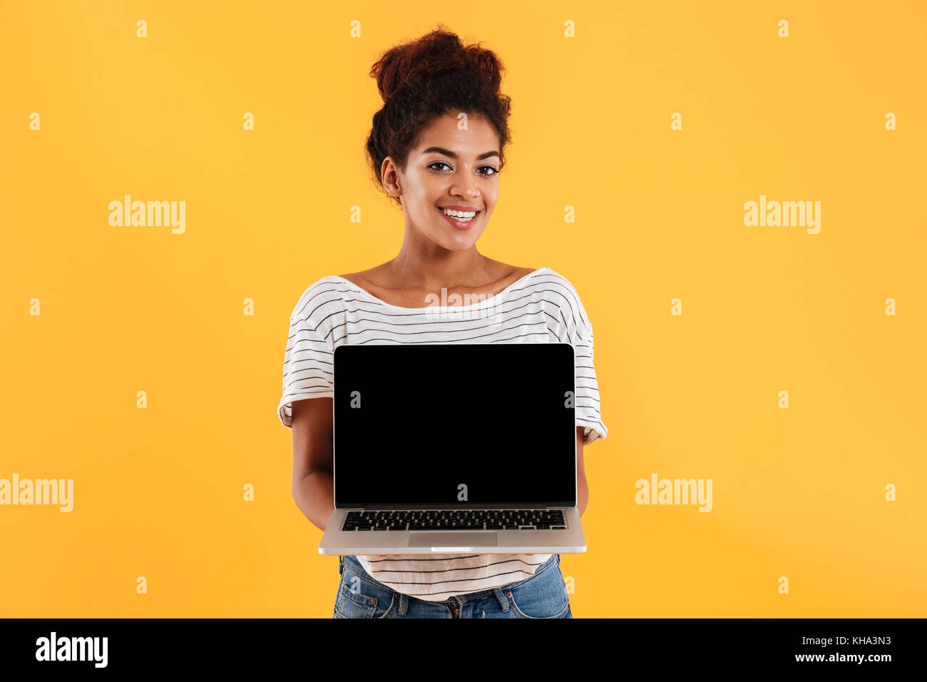 Young african beautiful lady with curly hair showing laptop computer ...
