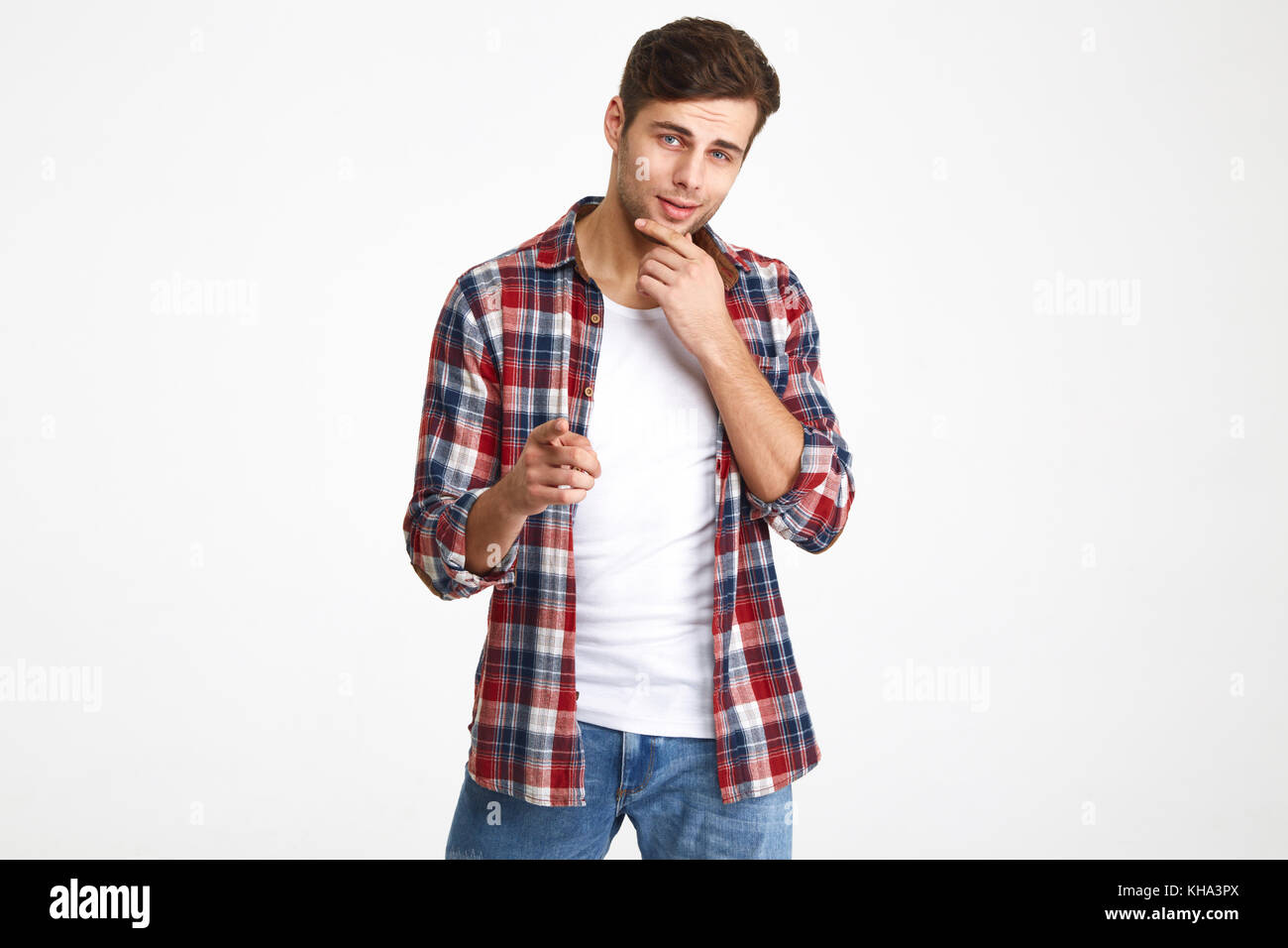 Portrait of a smiling charming man holding hand on his chin and ...