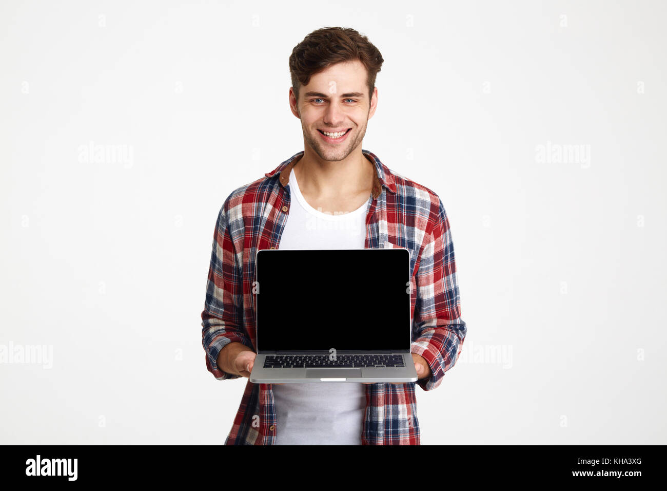 Portrait of a happy cheerful man showing blank screen laptop computer ...