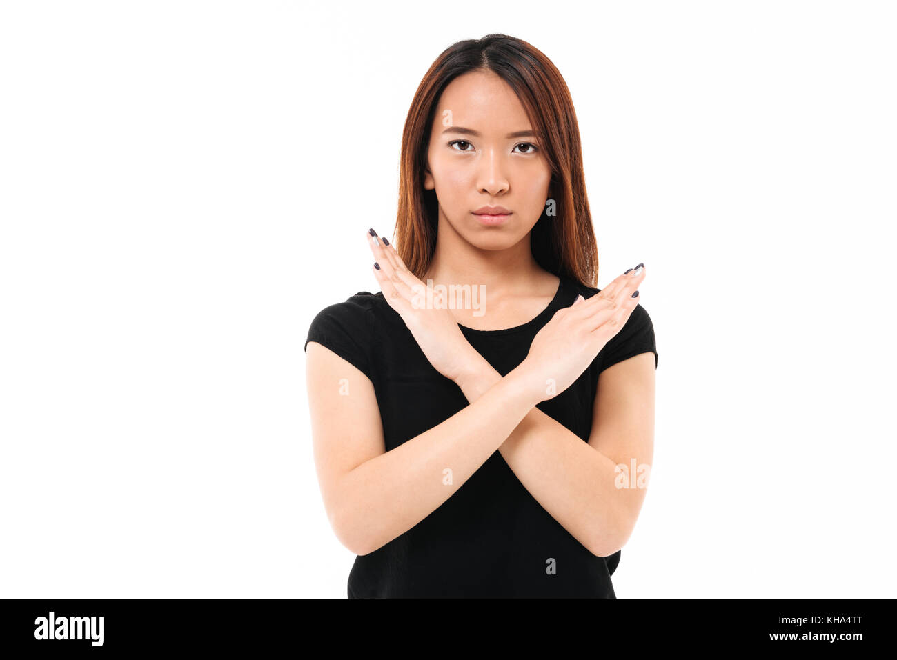 Close-up portrait of serious young asian lady showing stop gesture with ...