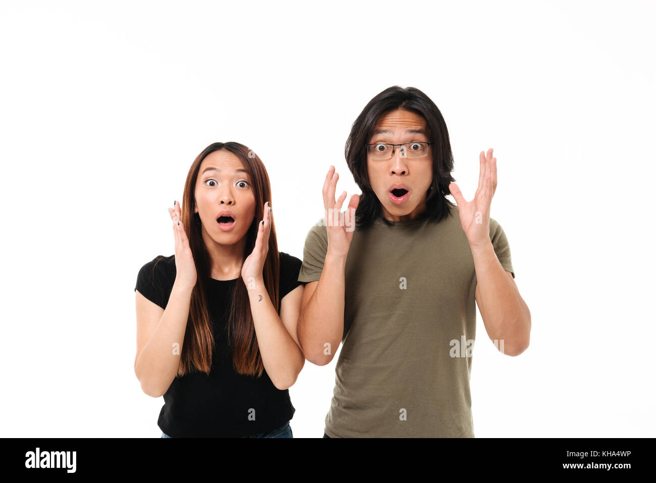 Portrait of a shocked young asian couple holding face at their face ...
