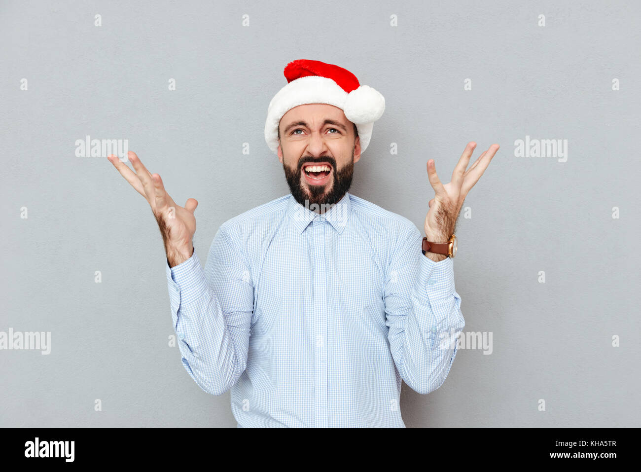Confused screaming Bearded man in business clothes and christmas hat ...