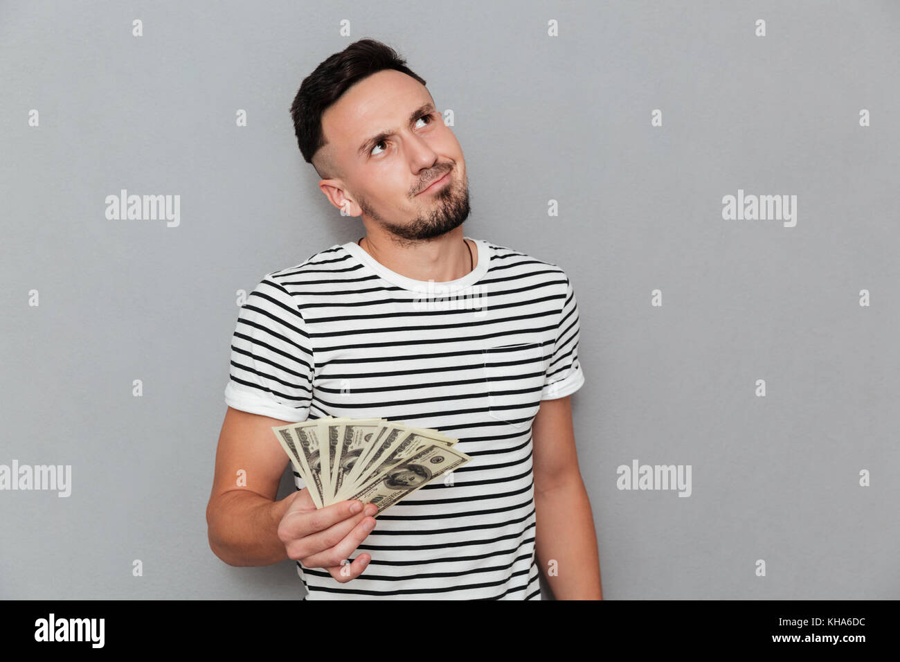 Pensive guy holding money hi-res stock photography and images - Alamy