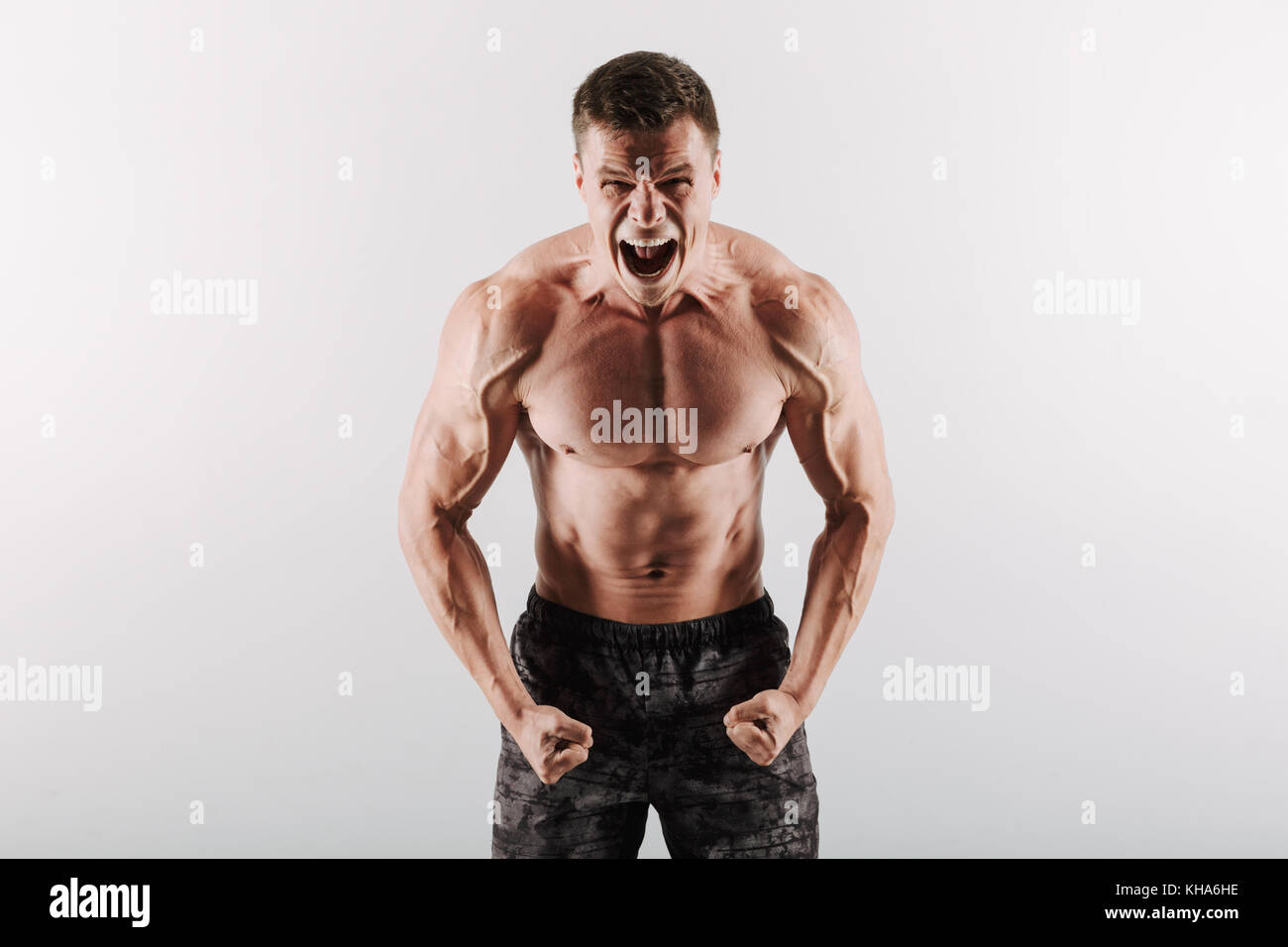 Photo of screaming young sportsman standing isolated over grey ...