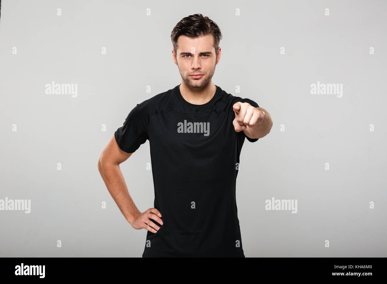 Portrait of a young confident sportsman pointing finger at camera ...