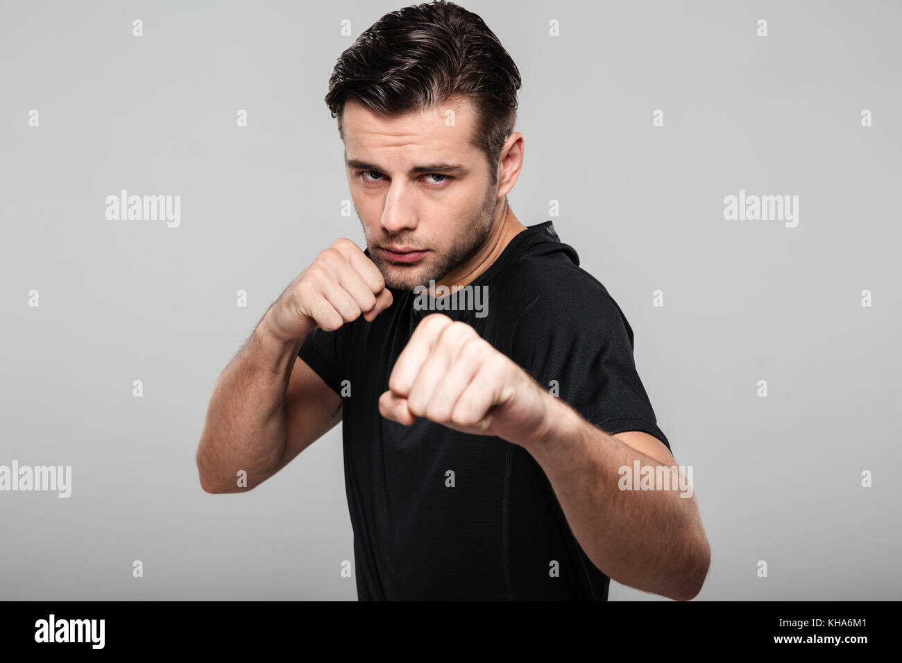 Close up portrait of a strong fit sportsman standing in a boxing ...