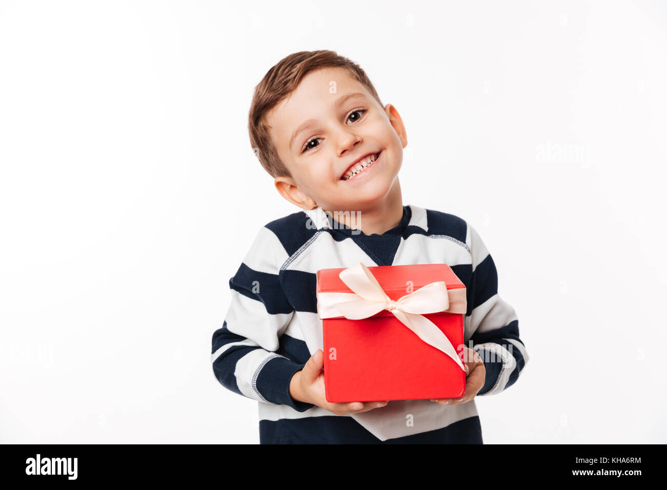 Portrait of a lovely cute little kid holding present box and looking at ...