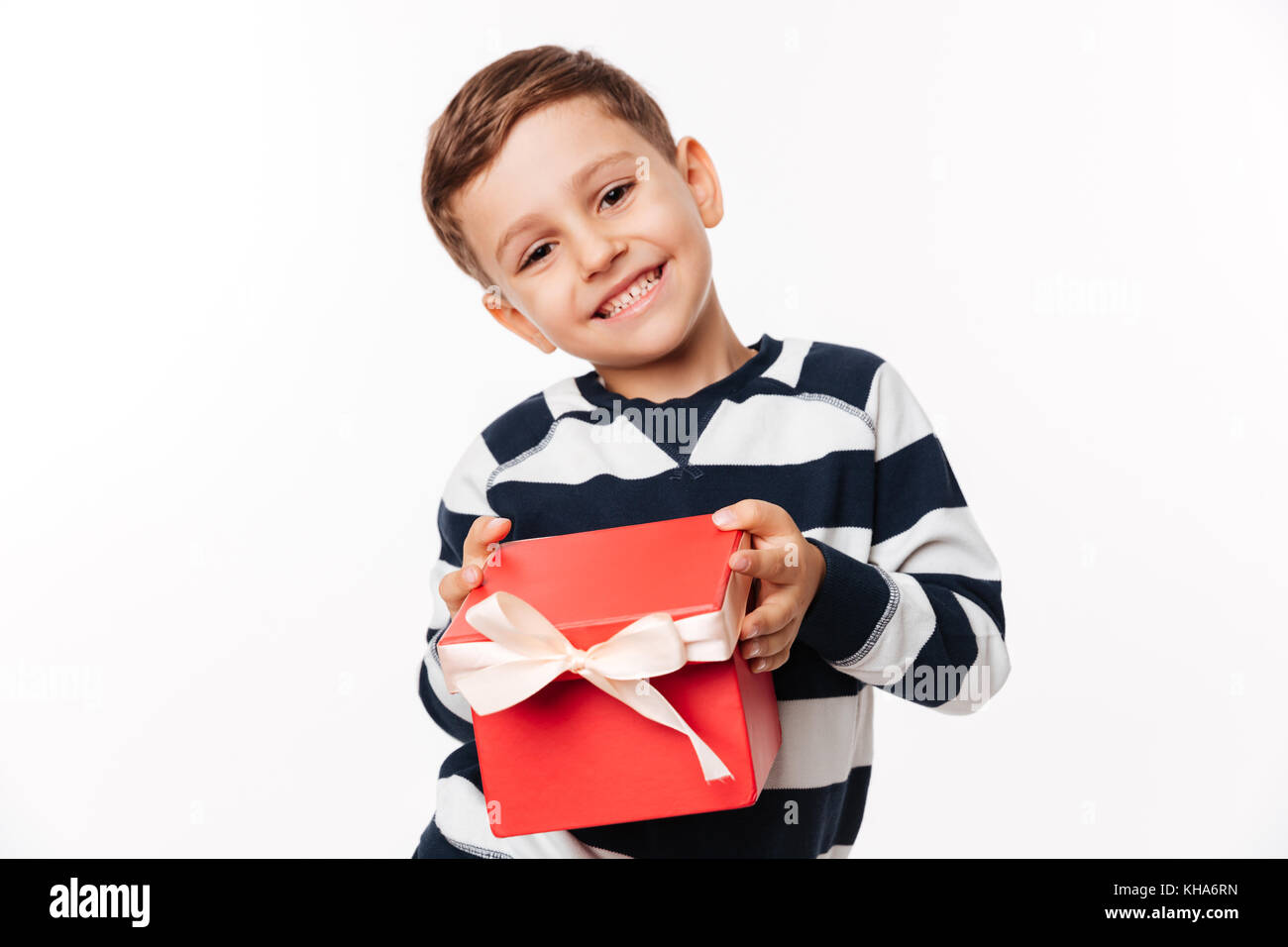 Portrait of a happy cute little kid holding gift box and looking at ...