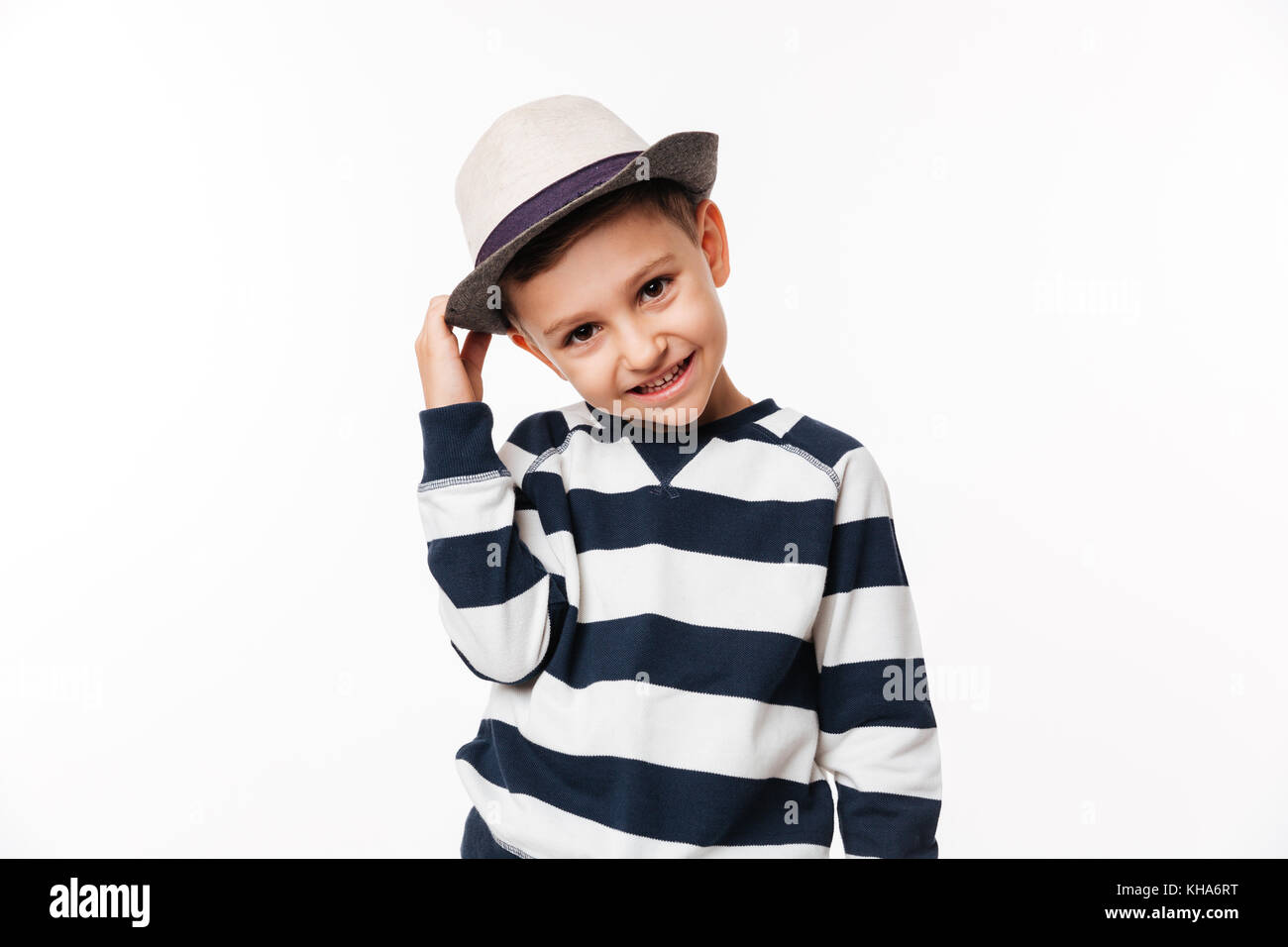Portrait of a happy cute little kid in a hat standing and looking at ...
